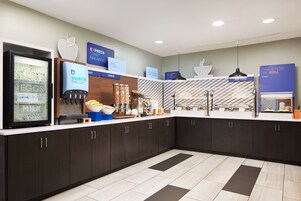 Um balcão de café da manhã moderno com diversas opções de comida, incluindo iogurte, ovos, leite, cereais e pratos quentes.