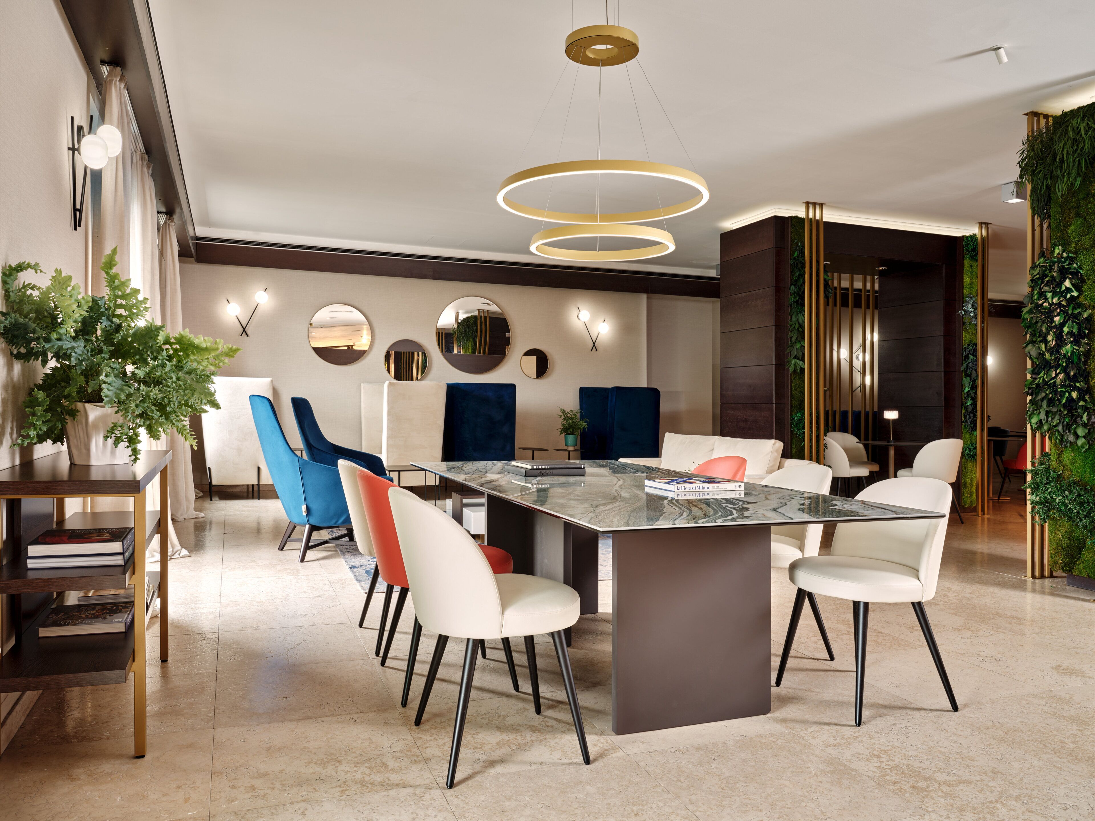 Uma sala de jantar moderna com mesa de mármore, várias cadeiras e iluminação pendente.