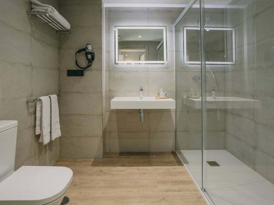 Uma casa de banho moderna com sanita, lavatório e cabine de duche com vidro.