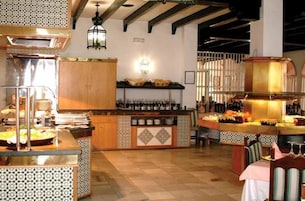 Interior de restaurante com área de bar, armários de madeira e piso estampado.