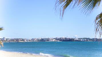 Uma praia com paisagem urbana ao fundo.