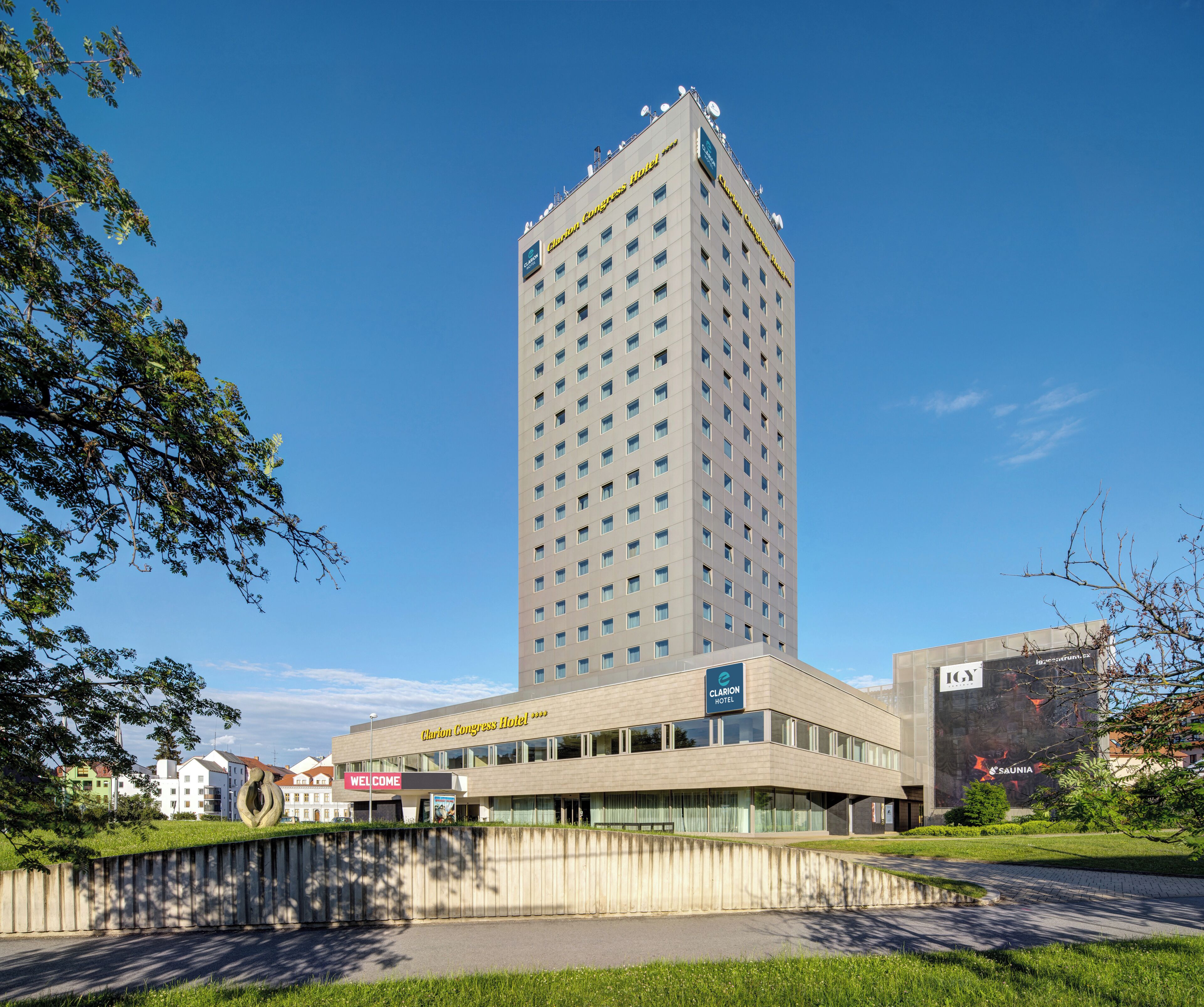 Um edifício de hotel alto com design moderno, entrada destacada e céu claro.
