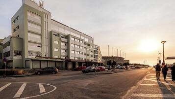 Um hotel com design arquitetônico moderno, destacando uma entrada imponente e vários andares.