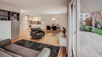 Um apartamento moderno com sala de estar, área de refeições, cozinha e vista para o jardim.