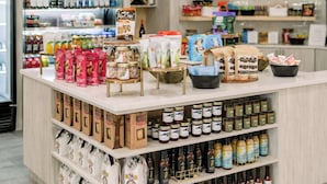 Exposição bem organizada de bebidas e lanches em uma loja, com prateleiras repletas de diversos produtos.
