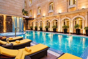 Piscina com espreguiçadeiras e área de hidromassagem.