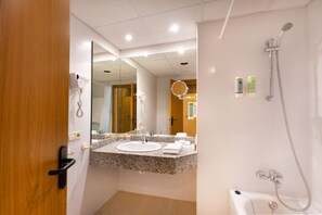 Uma banheira, artigos de higiene ecológicos, um secador de cabelo 