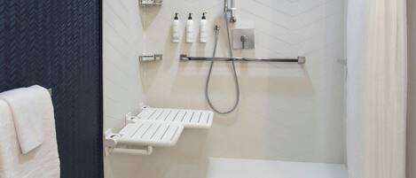 Uma área de chuveiro moderna com chuveiro manual e acessórios manuais, além de um porta-toalhas branco.