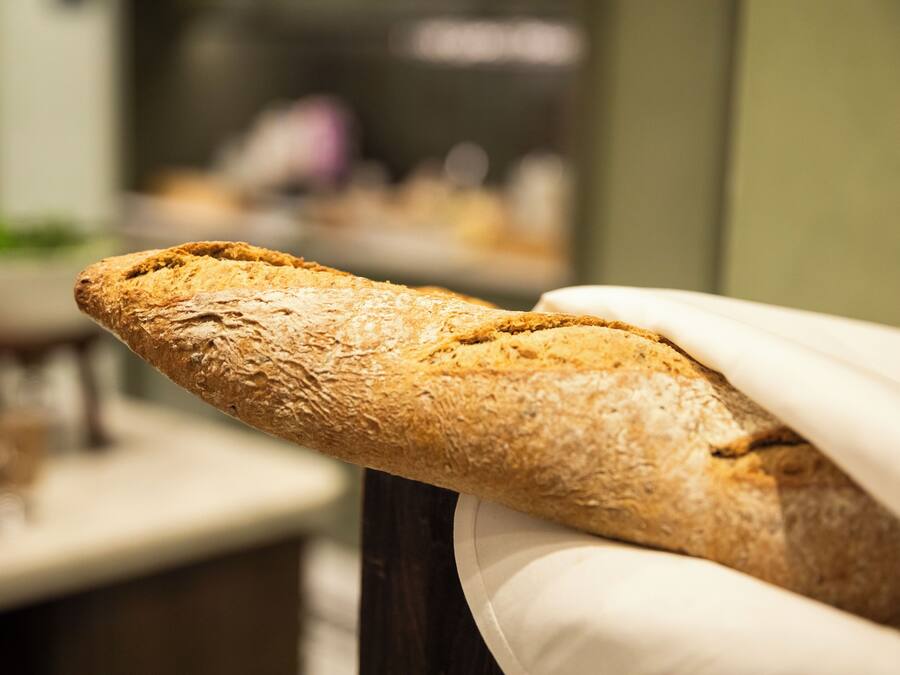 Uma baguete sobre uma superfície de madeira.