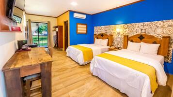 Quarto de hotel com duas camas, uma escrivaninha de madeira e uma televisão na parede.