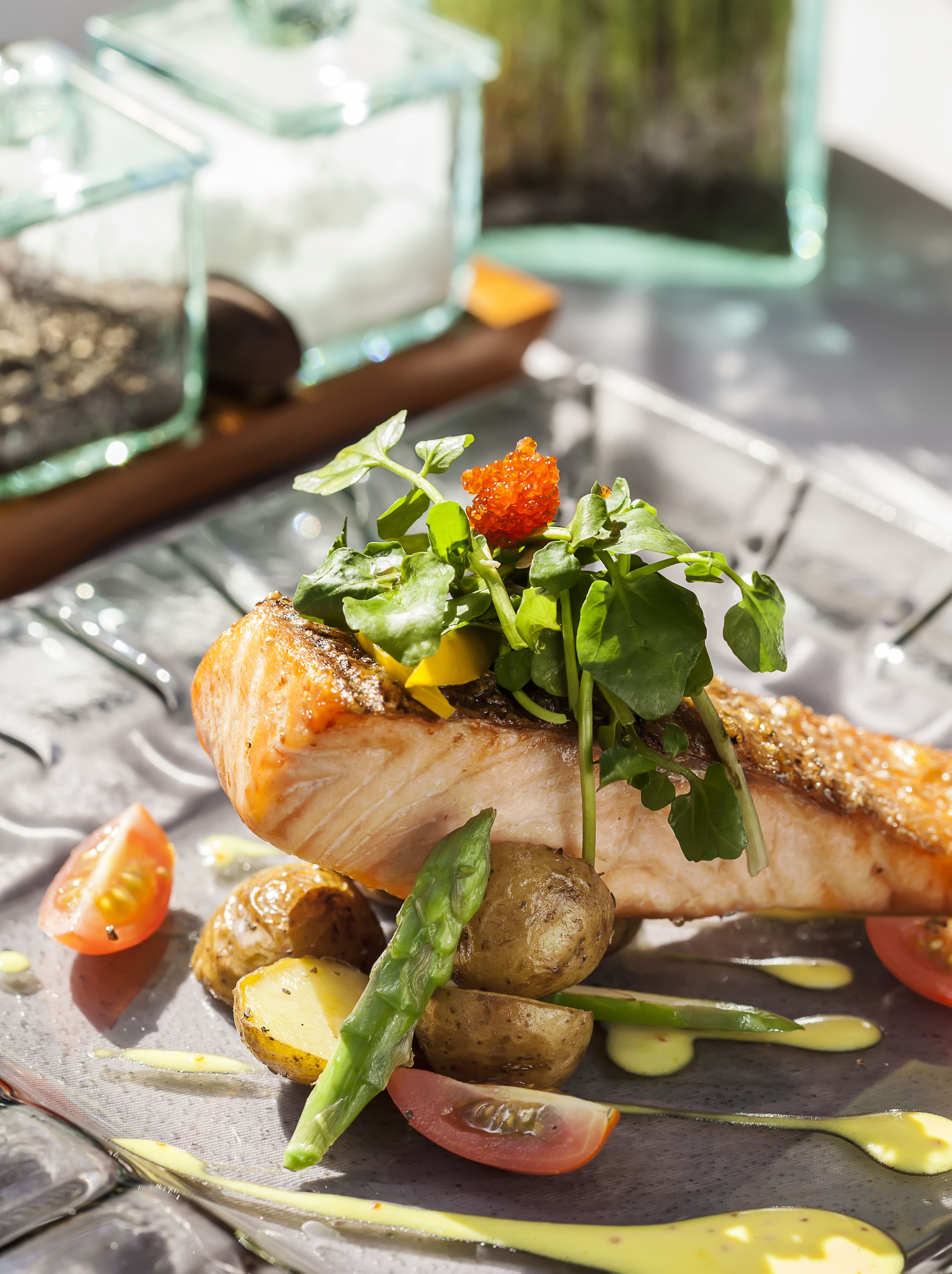 Um prato com peixe, vegetais e batatas.