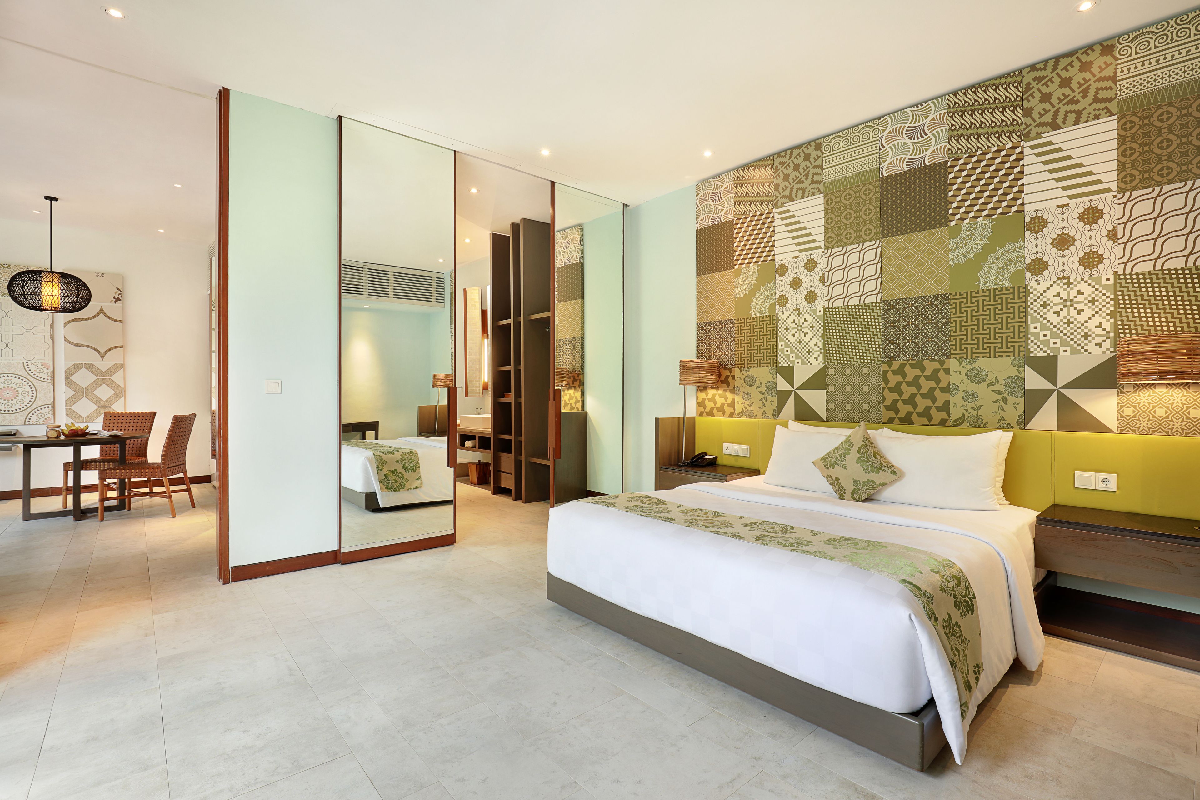 Quarto de hotel moderno com uma cama grande, uma escrivaninha com cadeira e um guarda-roupa.