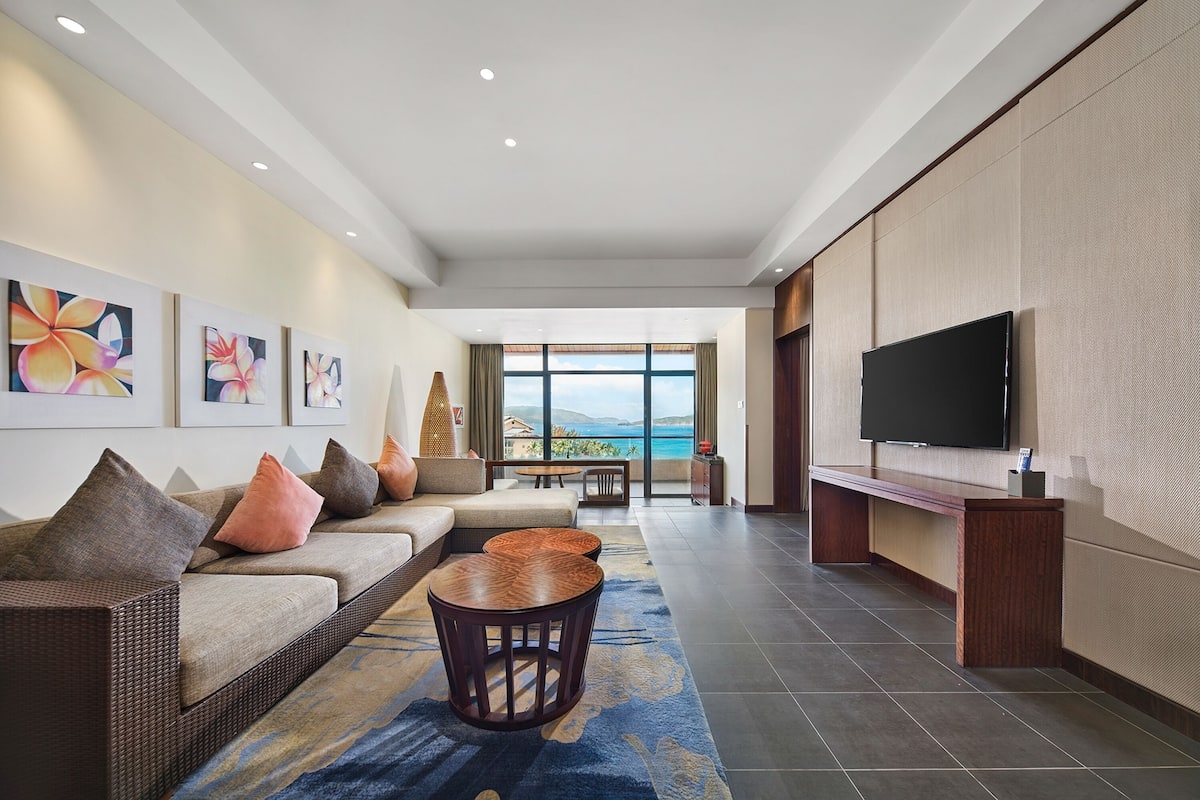 Uma sala de estar moderna com sofá, mesa de centro e obra de arte na parede.