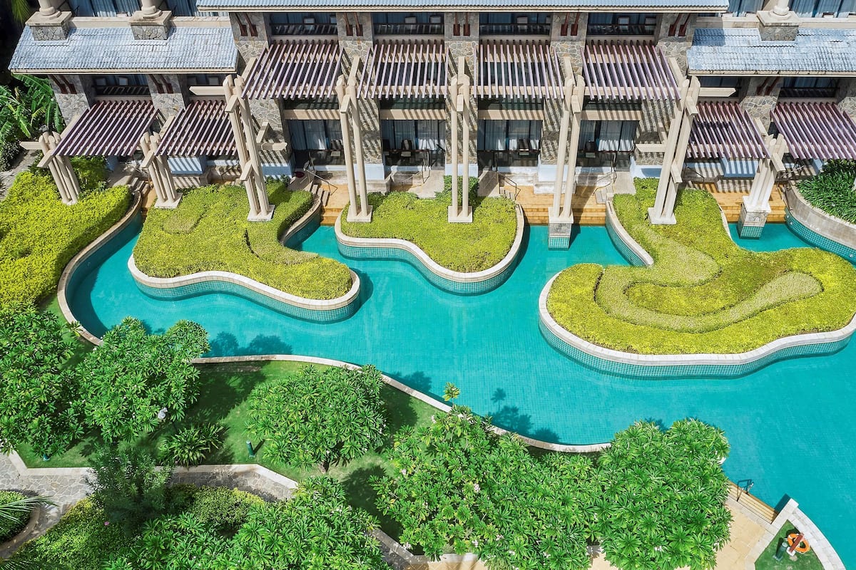 Resort com uma piscina grande, várias varandas e paisagismo exuberante.