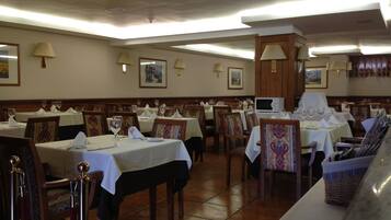 Um restaurante com várias mesas e cadeiras, cada conjunto com toalhas e guardanapos brancos.