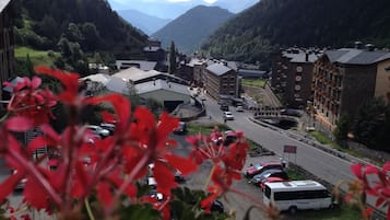 Uma cidade montanhosa com uma estrada cortando-a, cercada por edifícios e vegetação.