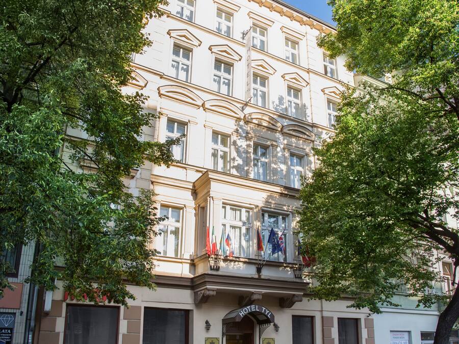 Um edifício de vários andares com estilo arquitetônico clássico, destacando uma entrada imponente com uma placa que diz 'HOTEL TYL'.