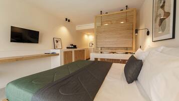 Quarto de hotel moderno com cama, televisão, parede de painéis de madeira e mesa de cabeceira.