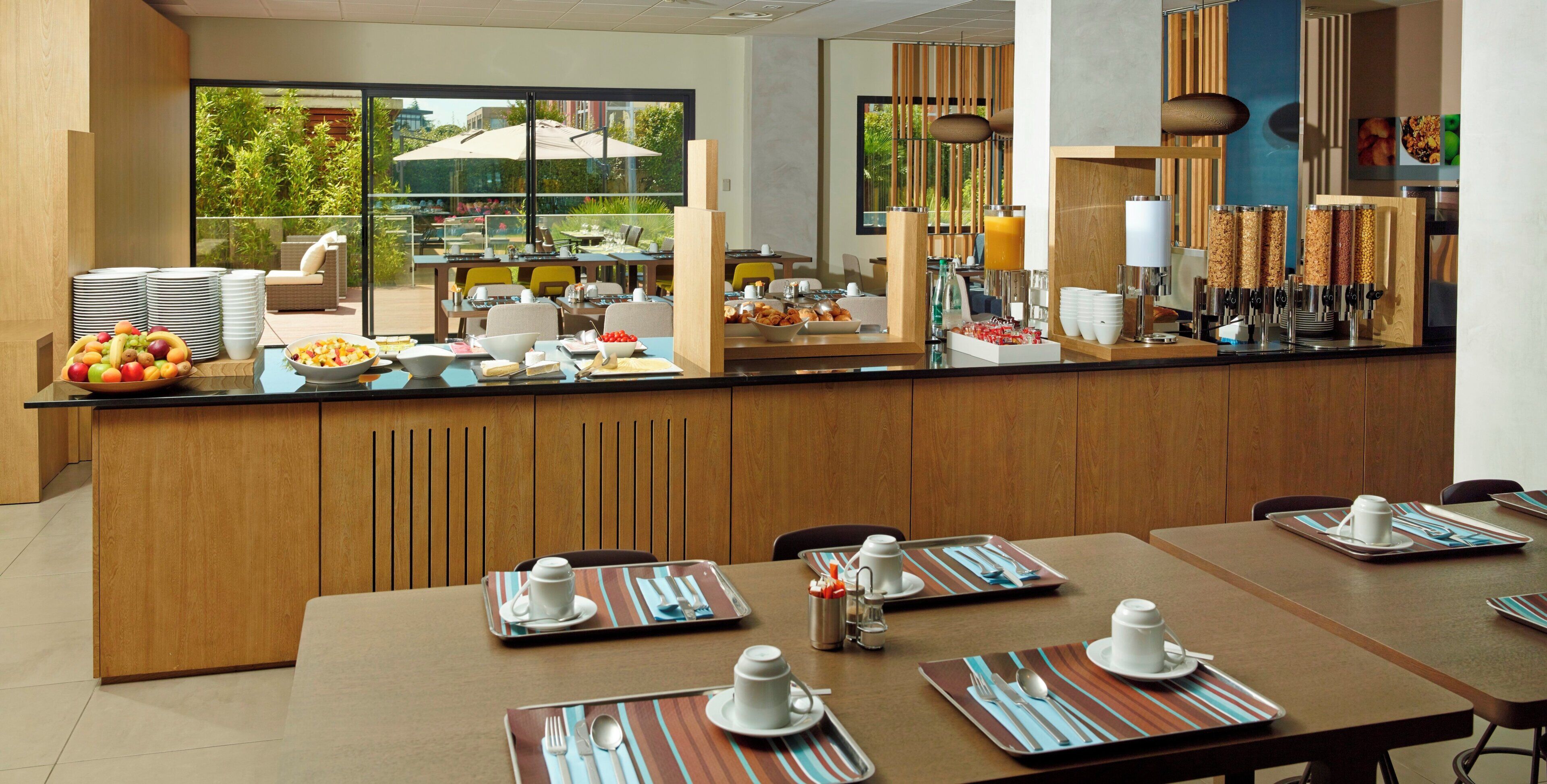 Um balcão de café da manhã moderno, com diversas opções de alimentos e área de estar com mesas e cadeiras.