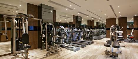Uma academia moderna com diversos equipamentos de exercícios, incluindo esteiras, aparelhos de musculação e pesos livres.