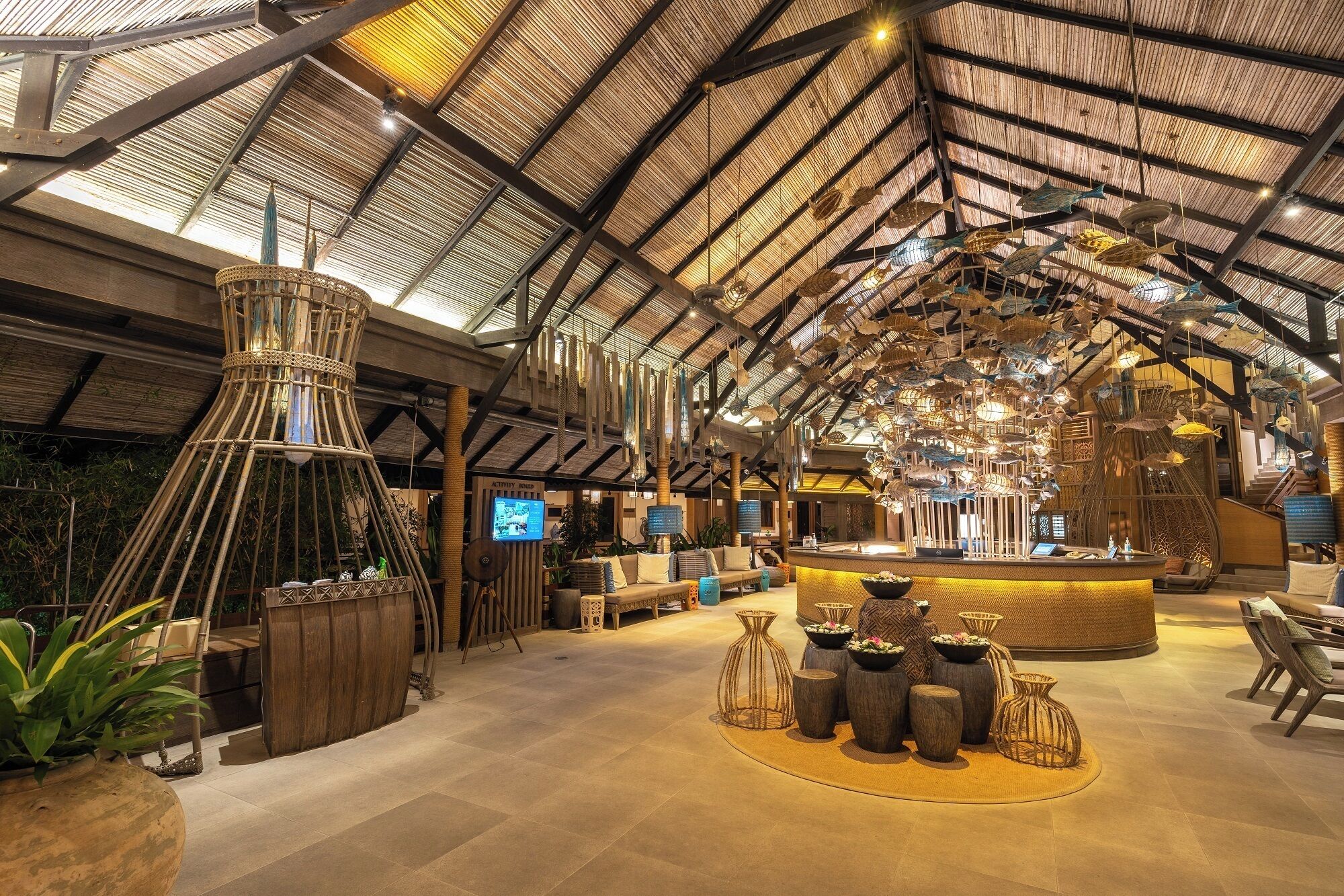 Um hall amplo com pé direito alto, área de estar central e exposição de itens decorativos.