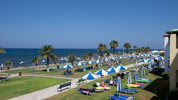 Na praia, espreguiçadeiras, guarda-sóis de praia, toalhas de praia