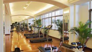 Academia com esteiras, bicicletas ergométricas e máquinas de peso.