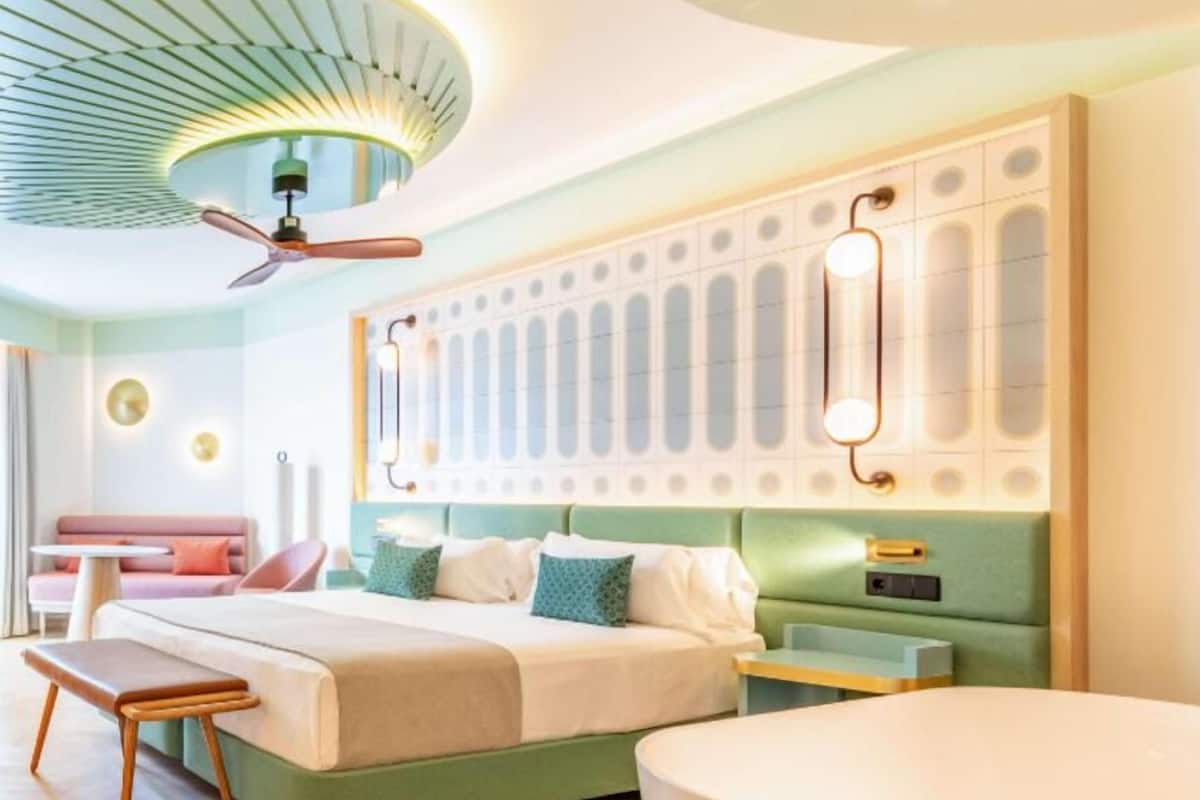 Quarto moderno com uma cama grande, uma toucador com espelho e uma banheira redonda.