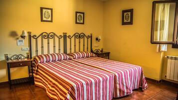 Quarto com cama de casal, duas mesas de cabeceira, um criado-mudo e uma luminária na parede.