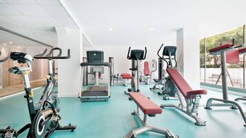 Uma academia com diversos equipamentos de exercício, incluindo esteiras, bicicletas ergométricas e aparelhos de musculação.