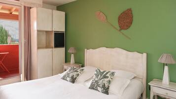Quarto com uma cama, duas mesas de cabeceira, um guarda-roupa e vista para o exterior.