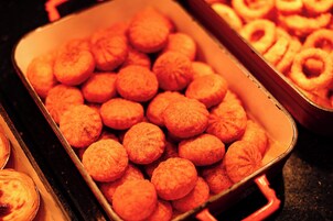 Uma bandeja com bolinhos redondos em uma cozinha.