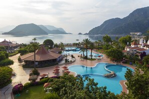 Um resort com uma piscina grande, um restaurante e vista para o mar.
