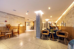 Um hall moderno com parede de pedra, móveis de madeira e balcão de recepção.