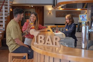 Uma área de bar com móveis de madeira e uma placa com a inscrição 'BAR'.