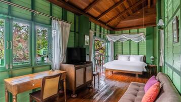 Um quarto com uma cama, uma escrivaninha, uma televisão e um sofá.