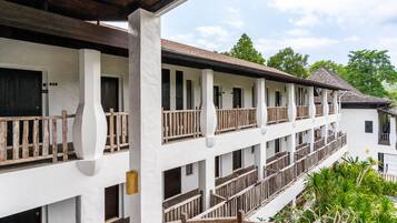 Um hotel com vários andares, paredes brancas e varandas de madeira.