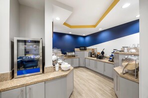 Uma cozinha moderna com geladeira embutida, micro-ondas e cafeteira.