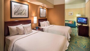 Quarto de hotel com duas camas, televisão e obras de arte nas paredes.