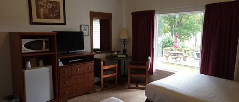 Quarto de hotel com duas camas, uma escrivaninha com computador, televisão, micro-ondas e frigorífico.