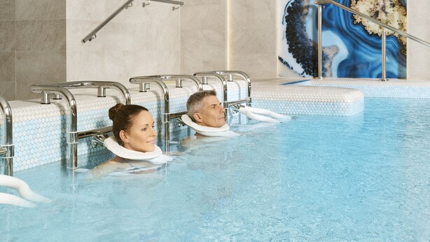 Piscina com guarda-corpo de segurança e parede em mosaico.