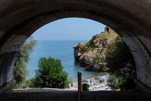 Uma praia privada, espreguiçadeiras, guarda-sóis de praia, windsurf 