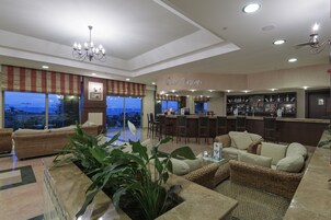 Ampla área de estar com assentos confortáveis, bar e grandes janelas com vista.