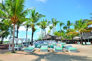 Na praia, praia de areia branca, espreguiçadeiras, guarda-sóis de praia