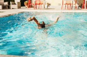 Uma pessoa em uma piscina com água espirrando.