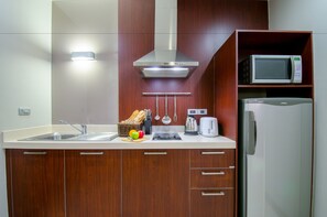 Suite Deluxe, 1 cama king-size, varanda | Kitchenette privada | Um frigorífico/congelador grande, um micro-ondas, uma cafeteira/bule 