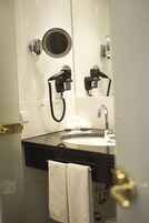 Casa de banho com espelho, secador de cabelo e lavatório.