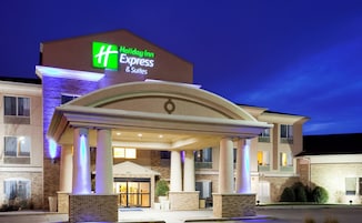 Um hotel Holiday Inn Express & Suites com entrada coberta e fachada de tijolos.