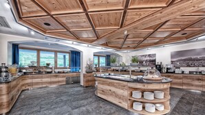 Cozinha moderna com ilha de madeira, grandes janelas e chão em tijolo de pedra.