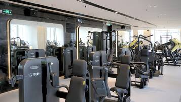 Uma academia com diversos equipamentos de exercício, incluindo aparelhos de musculação e esteiras.